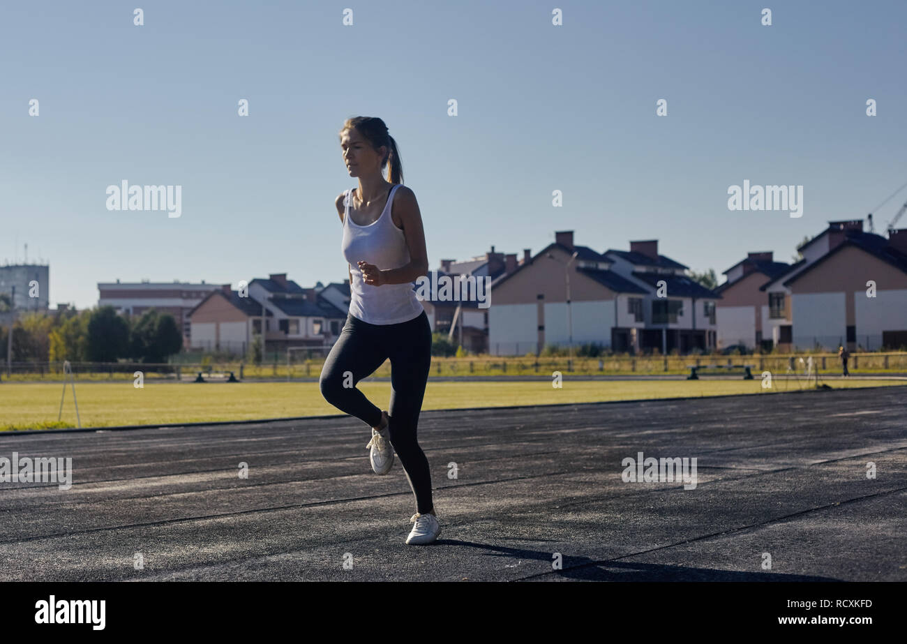 Pretty woman jogging at park in sunrise light Stock Photo - Alamy