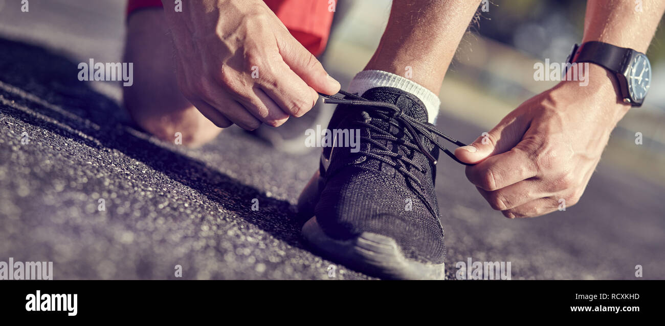 Running shoes - closeup of man tying shoe laces Stock Photo - Alamy