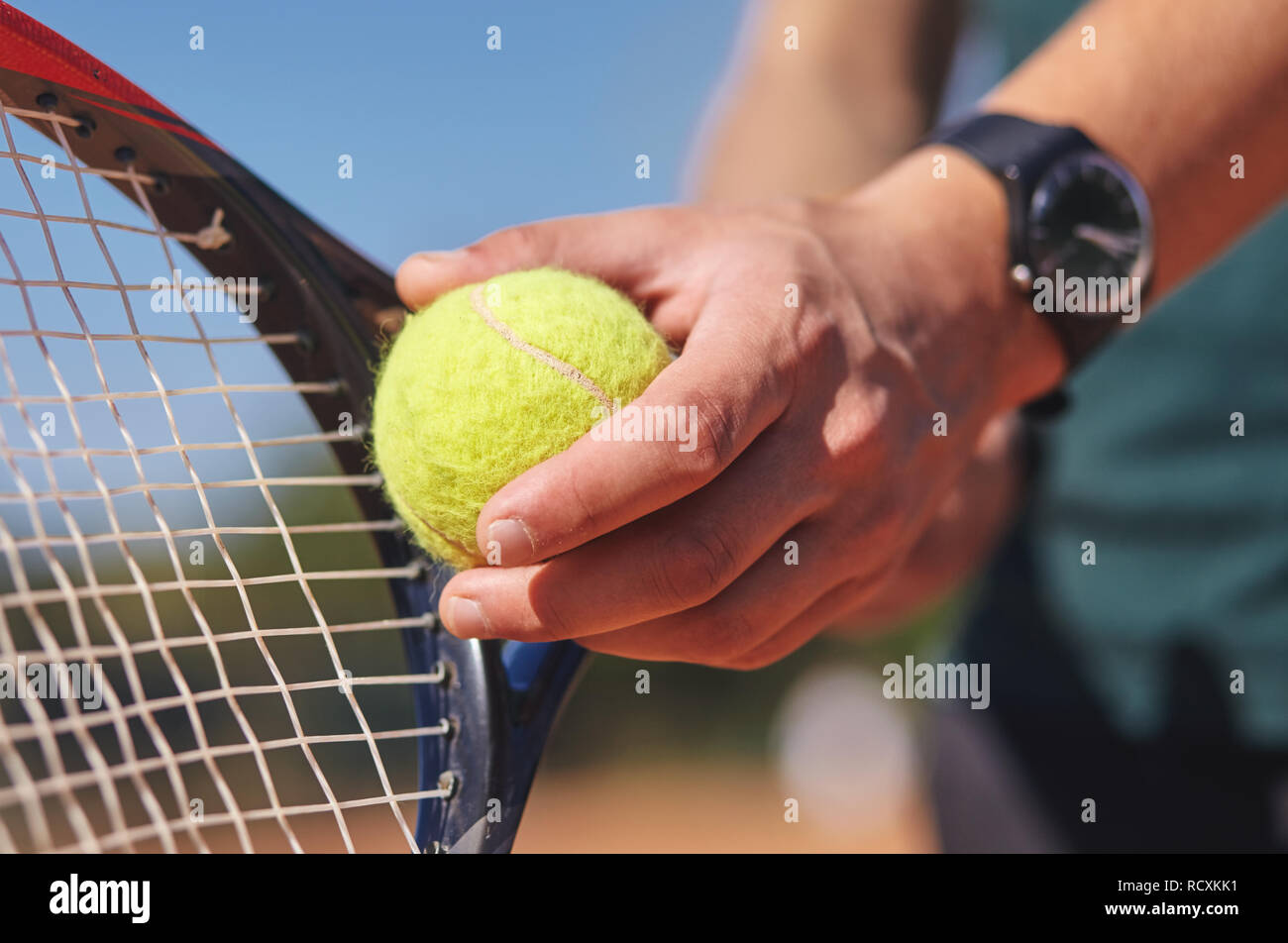 a Tennis player holding racket and ball in hands Stock Photo - Alamy
