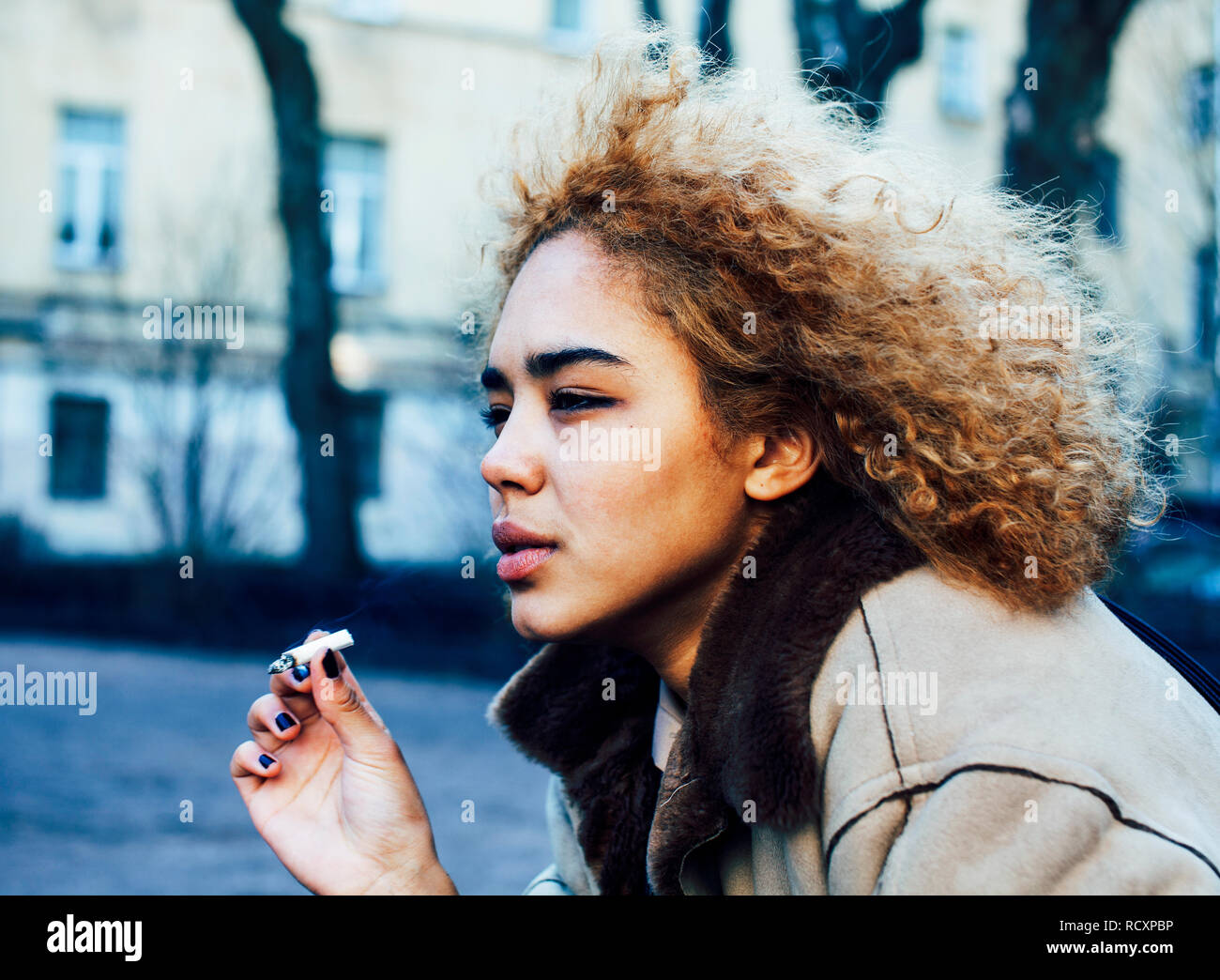 young pretty girl teenage outside smoking cigarette, looking lik Stock Photo - Alamy