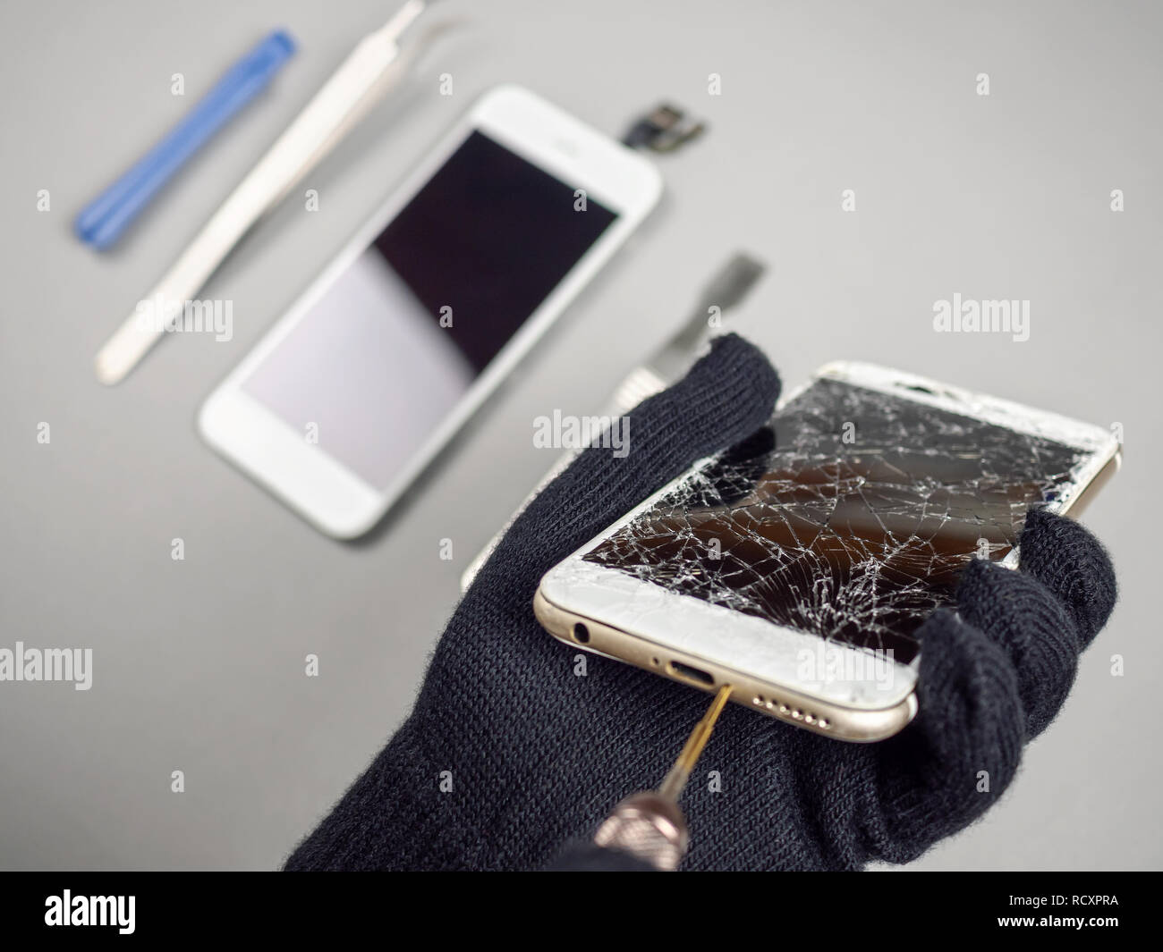 Technician or engineer opening broken smartphone for repair or replace ...