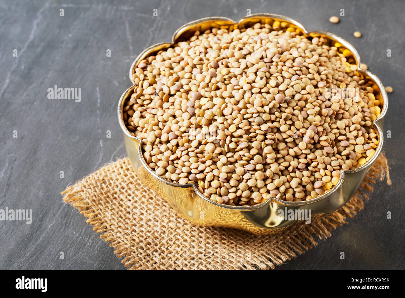 Raw lentils on balck stone background. Healthy vegetarian food concept ...