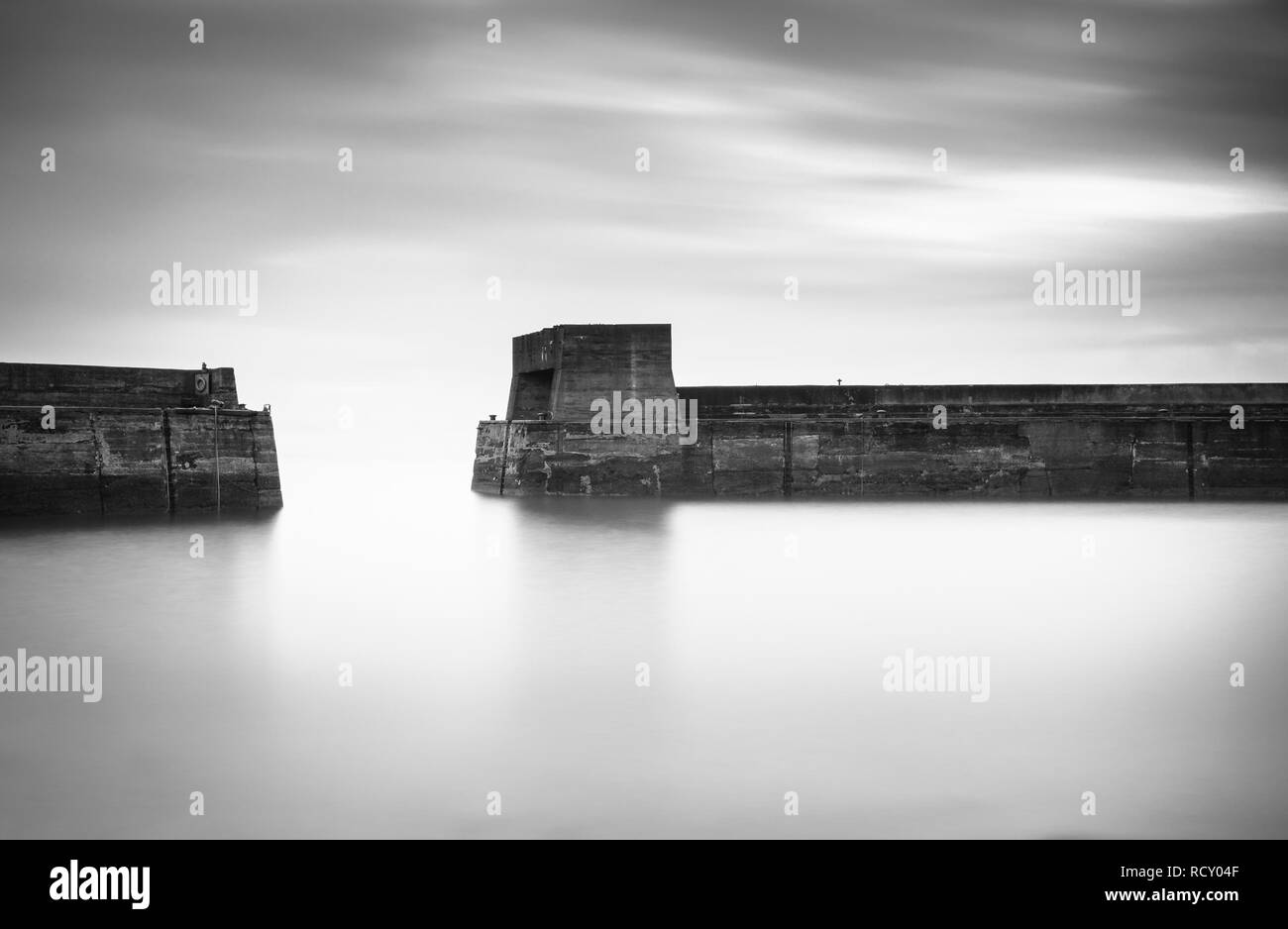 A early morning long exposure of the harbour walls and tower at Craster ...