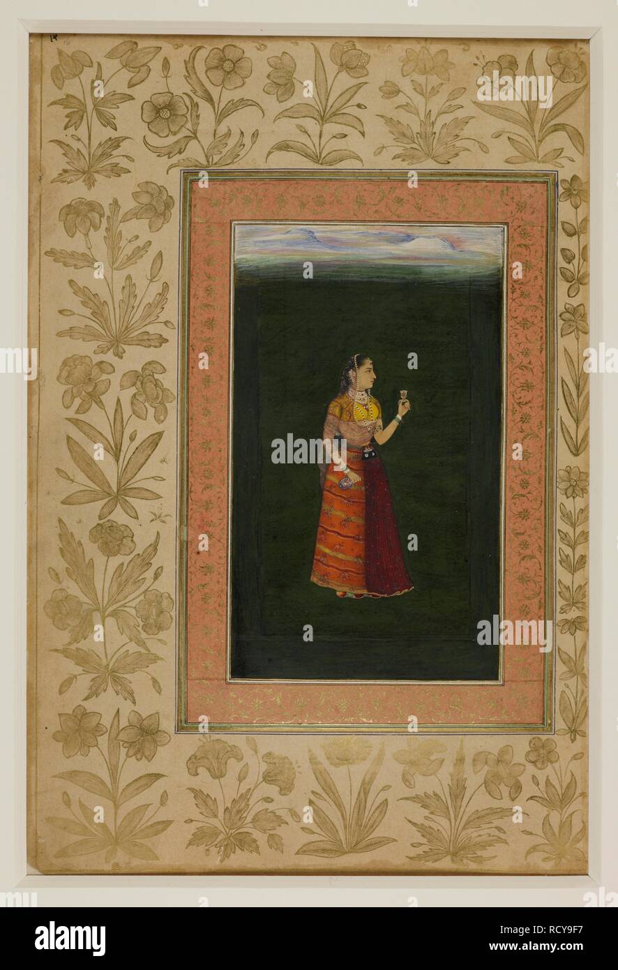 A lady stands facing right, holding a jewelled gold cup and a glass ...