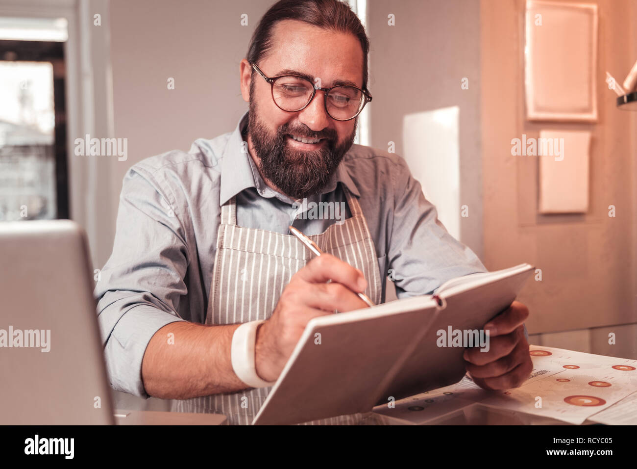 Waiter making important notes in his notebook Stock Photo - Alamy