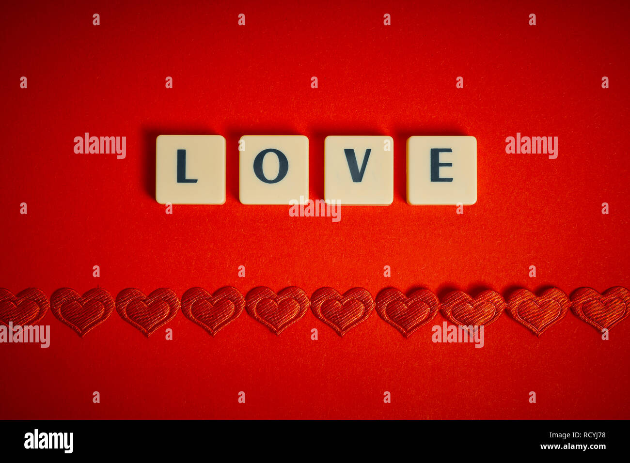 the love word arranged from blocks with letters on a beautiful red ...