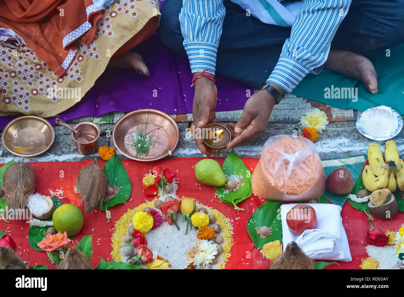 In a Hindu ritual for the ancestors, a man places a deepa or light ...