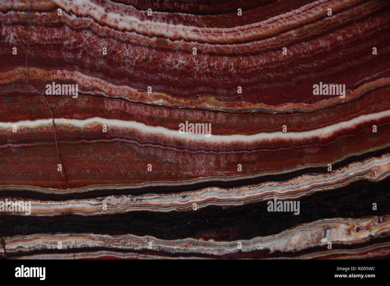 The structure of Onyx, a bright red color with thin veins and waves, is ...