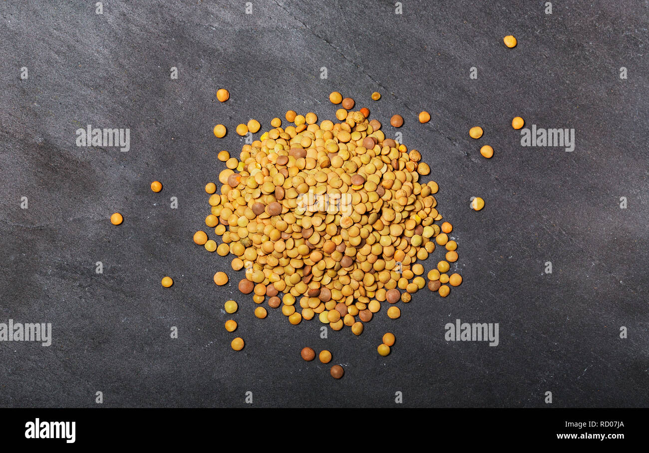 Raw lentils on balck stone background. Healthy vegetarian food concept ...