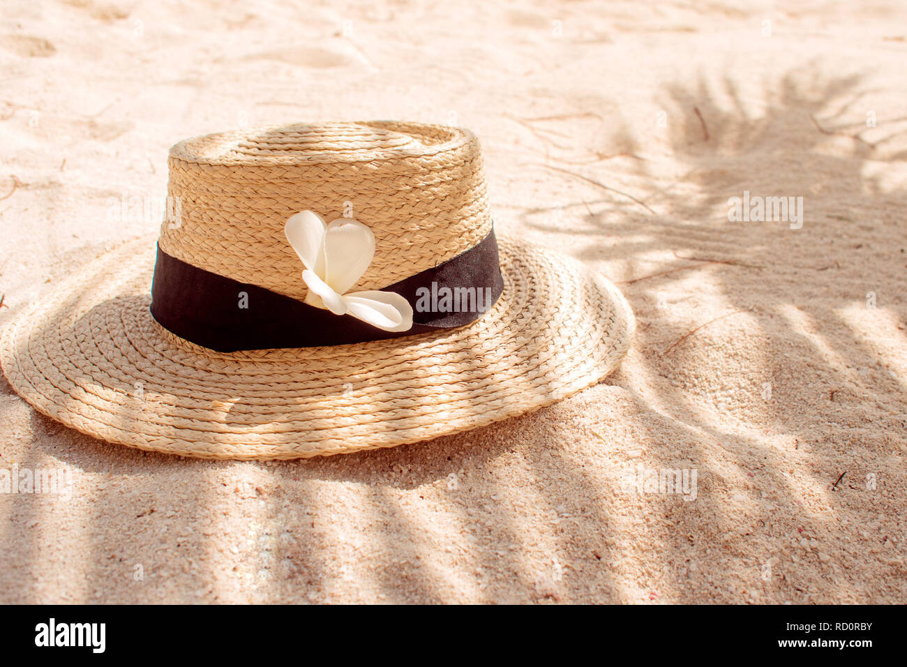 Straw hat on sand, sun protection concept. Still life with a hat and ...