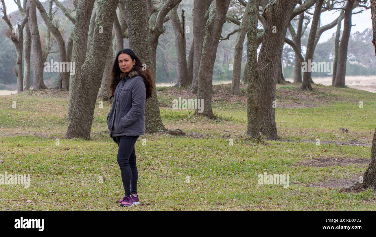 Asian woman with parka standing in front of trees in North Carolina ...