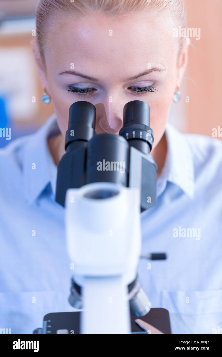 Girl with a slide for the microscope University Hospital. Attractive ...