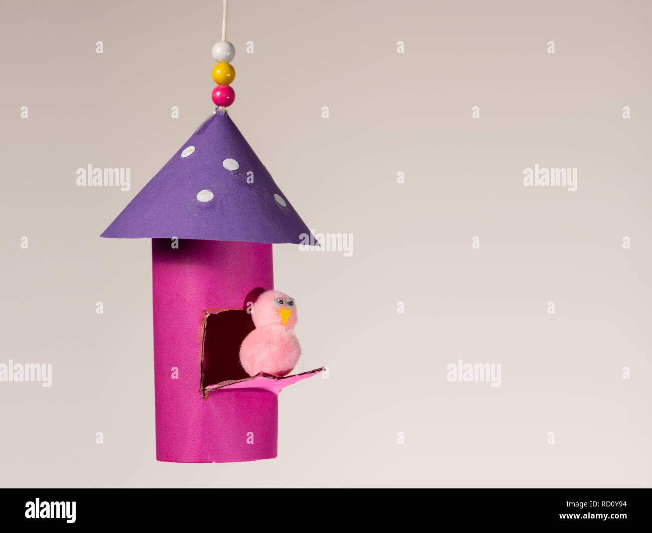 Handicraft of a colorful bird house and a small bird made of toilet ...