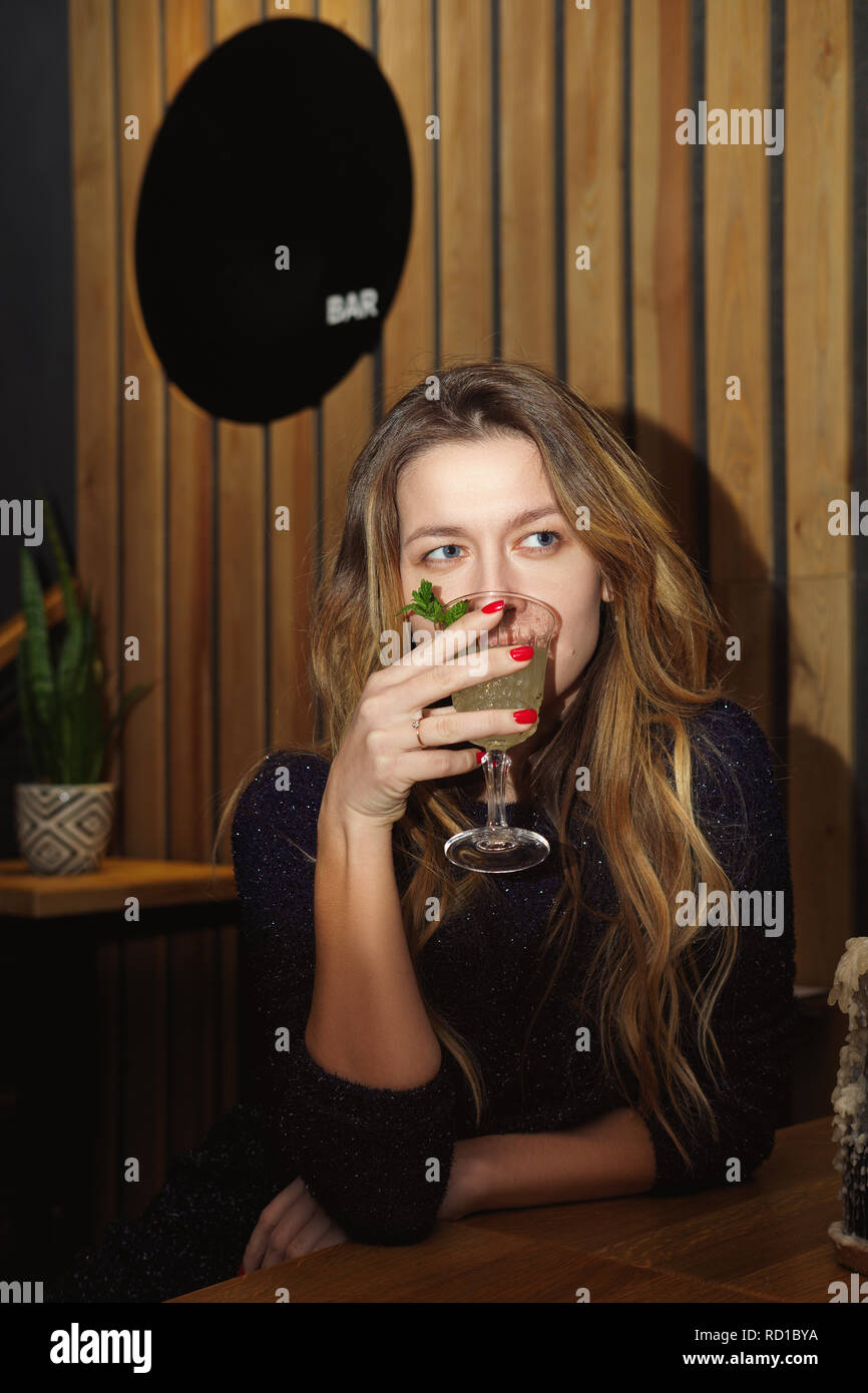 Pretty girl drinking cocktail in bar Stock Photo - Alamy