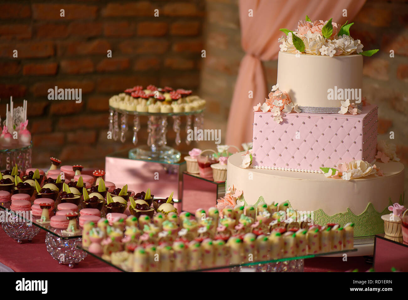 Large assortment of bite-sized cakes and a large three tiered cake ...