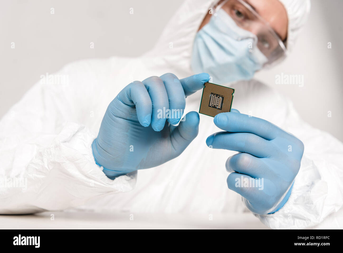 selective focus of microprocessor in hands of scientist in googles on ...