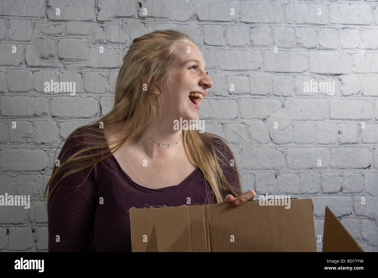 Happy girl opening a cardboard box Stock Photo - Alamy