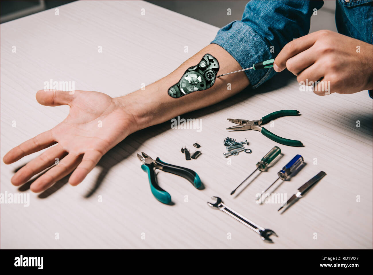 cropped view of man repairing metallic mechanism with screwdriver and ...