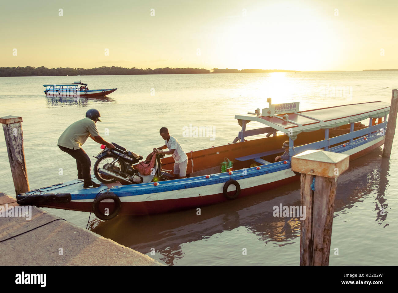 Loading a moped on a traditional boat on the Suriname river Stock Photo ...