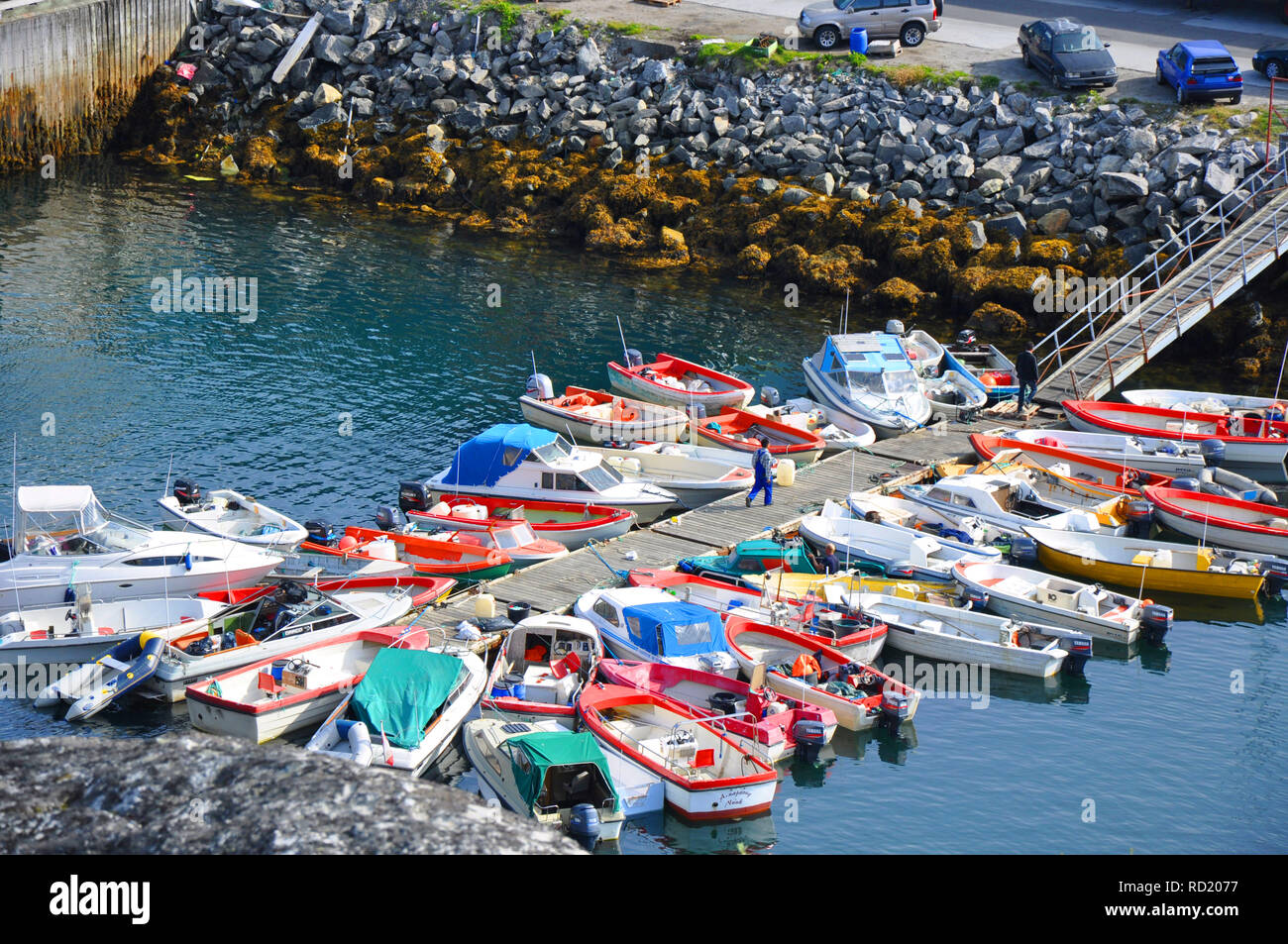 Small fishing and transportation boats docked tightly around a pier in ...