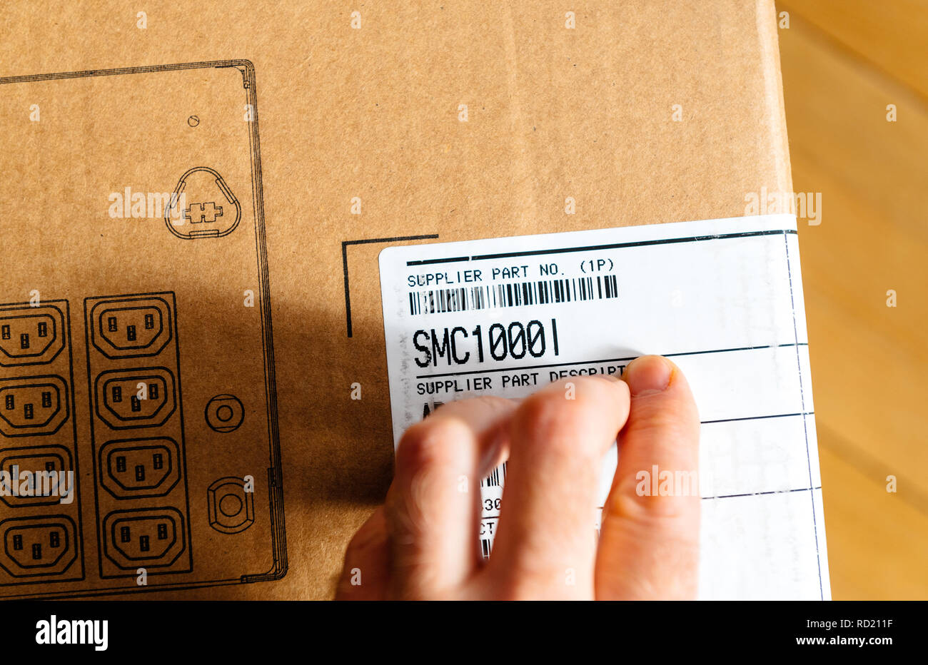 PARIS, FRANCE - MAR 29, 2018: Man inspecting barcode of APC Smart-UPS ...