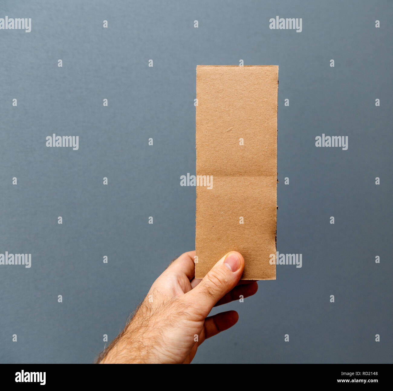 Factory worker male hand showing against gray background a corrugated ...