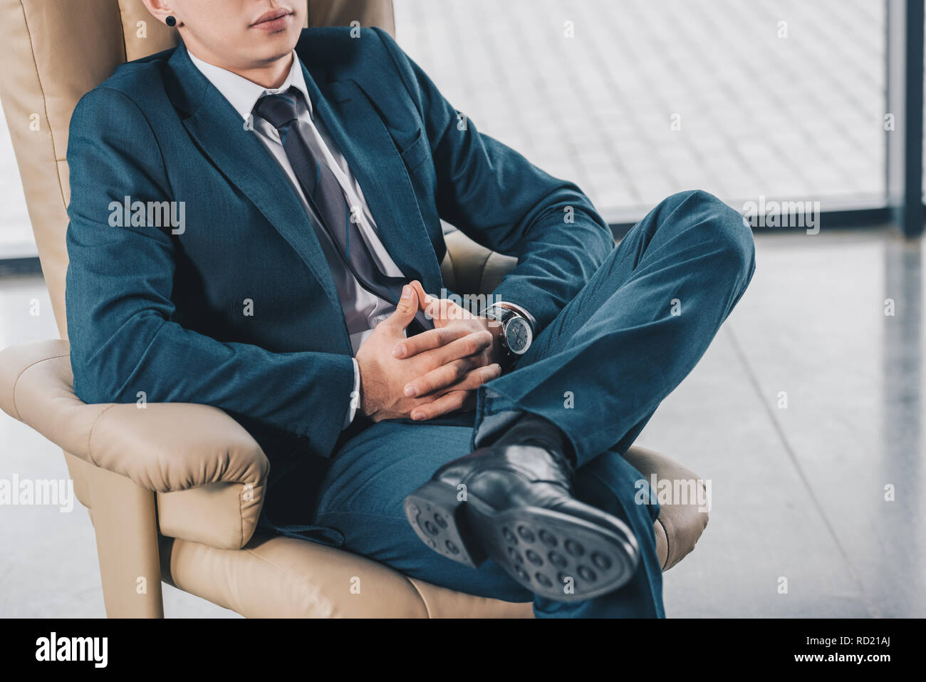 cropped shot of confident young leader sitting in chair at workplace ...