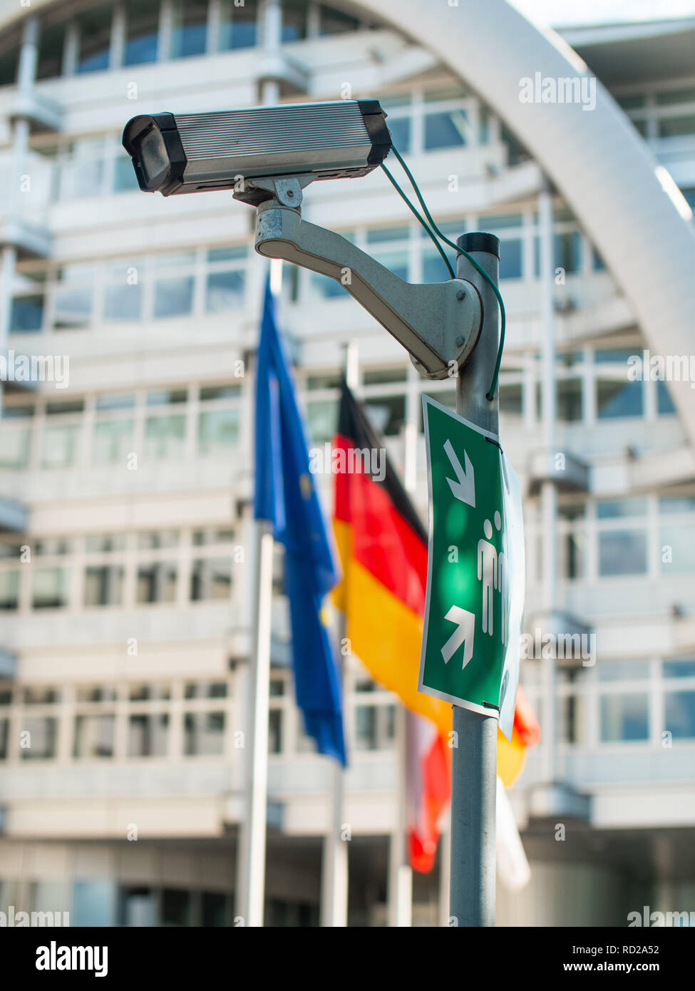 A security camera on a pole with European flags in the background and ...