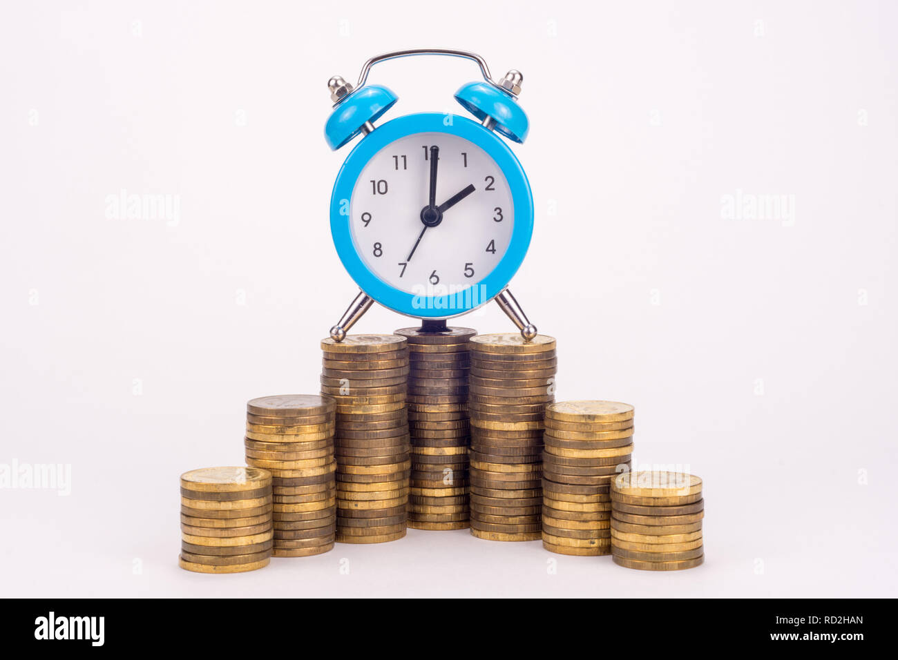 The clock is on a stack of coins Stock Photo - Alamy