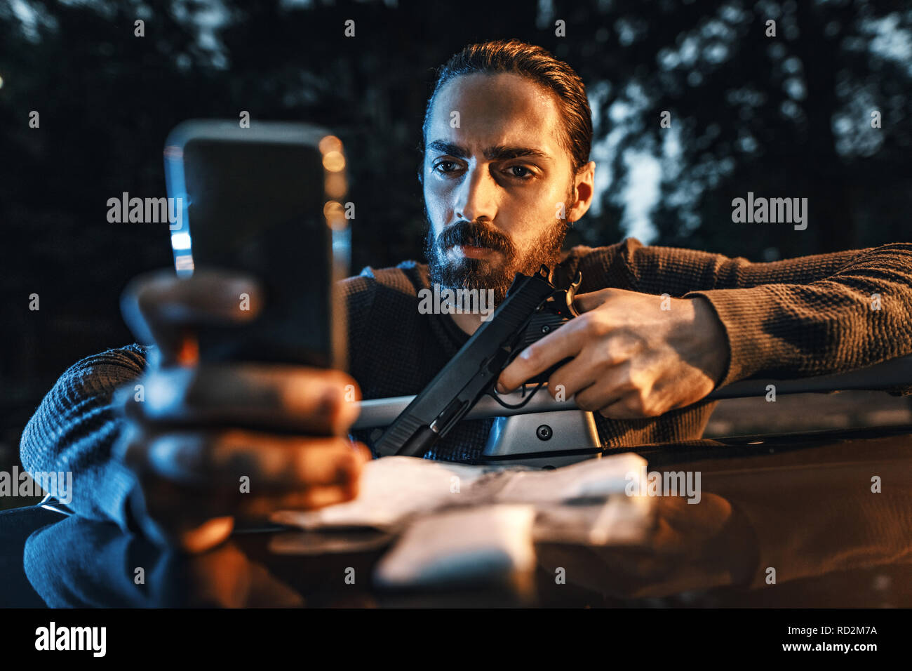 Dangerous criminal man with gun exchanging messages with his criminal ...