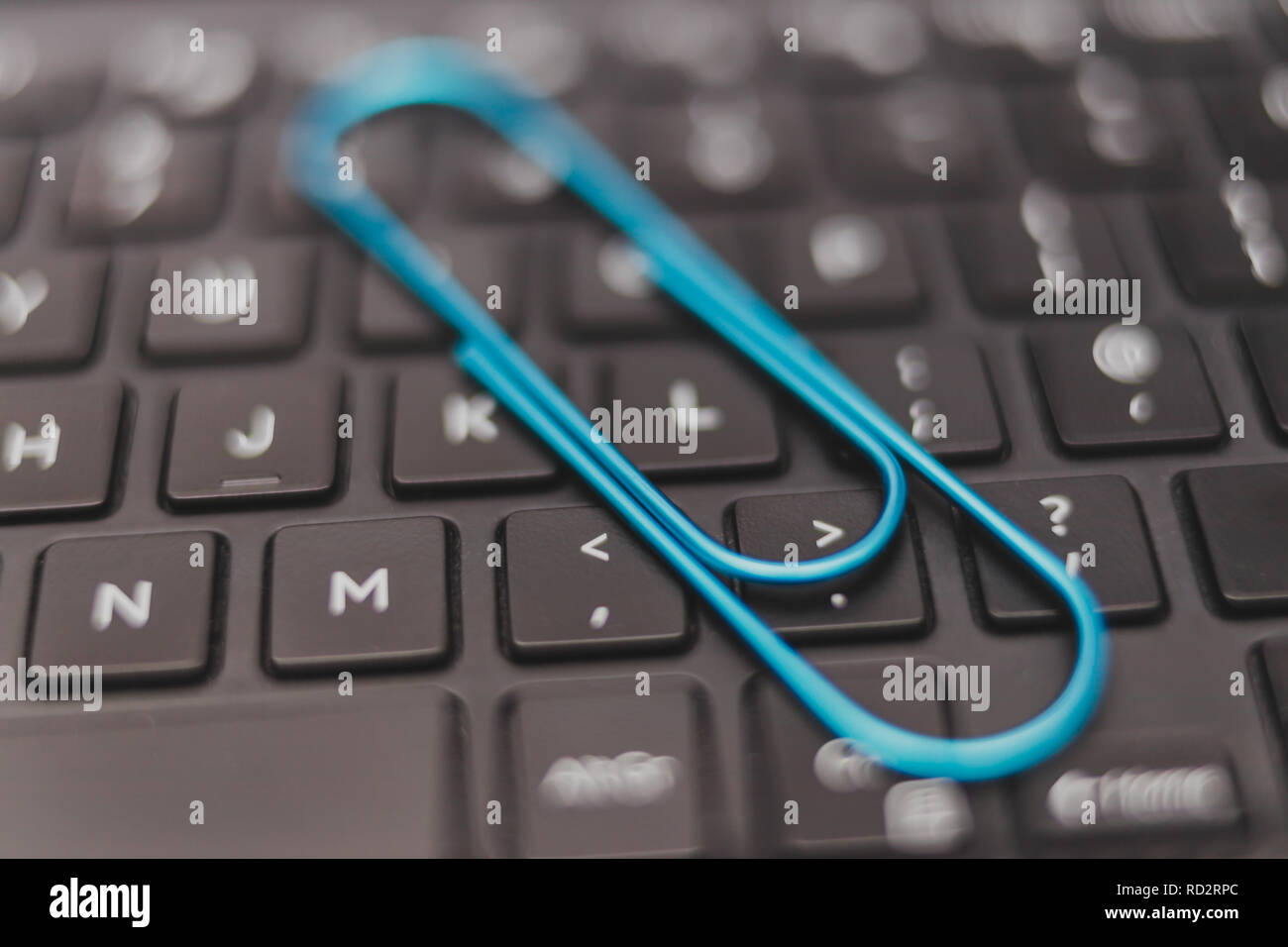 laptop keyboard with clip symbol of email attachments, close-up shot at ...