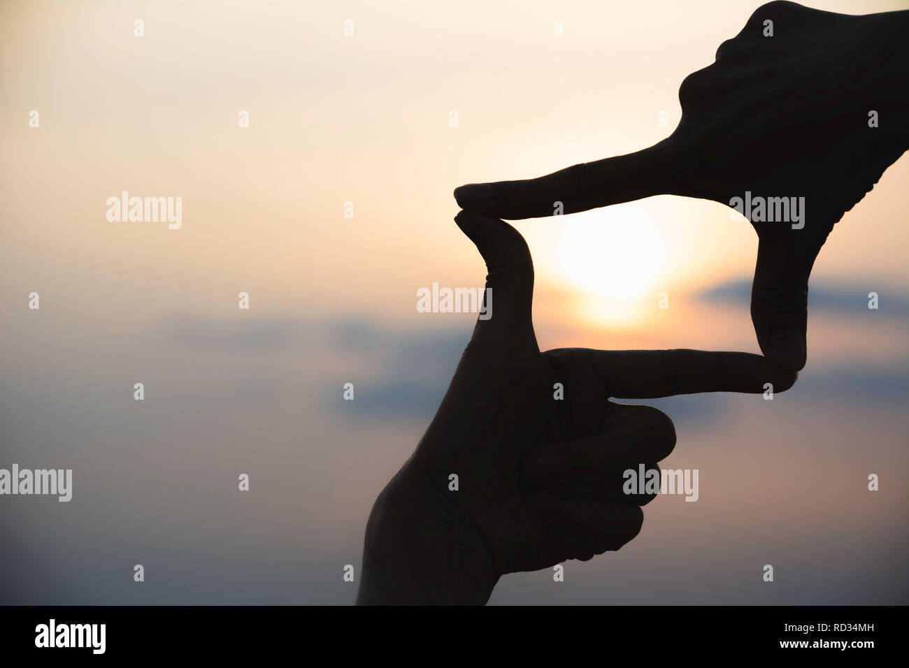 Hands making frame with sunset. Close up of woman hands making frame ...
