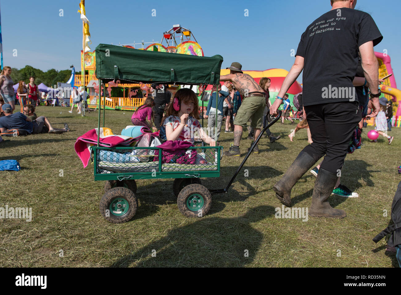 Child being pulled in a cart at a music festival Stock Photo - Alamy