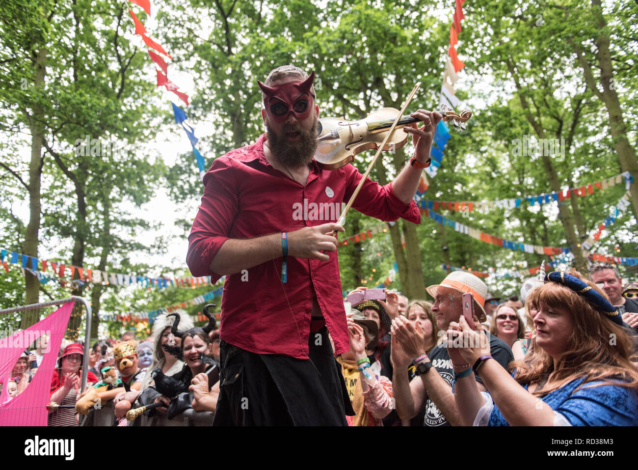 Man dressed as the devil playing the violin at a music festival Stock ...