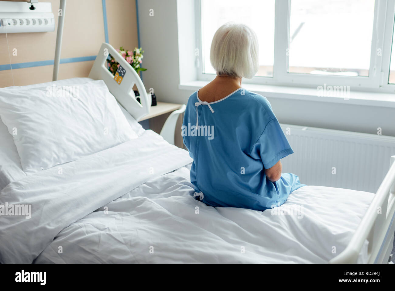 back view of senior woman sitting on bed in hospital ward Stock Photo ...