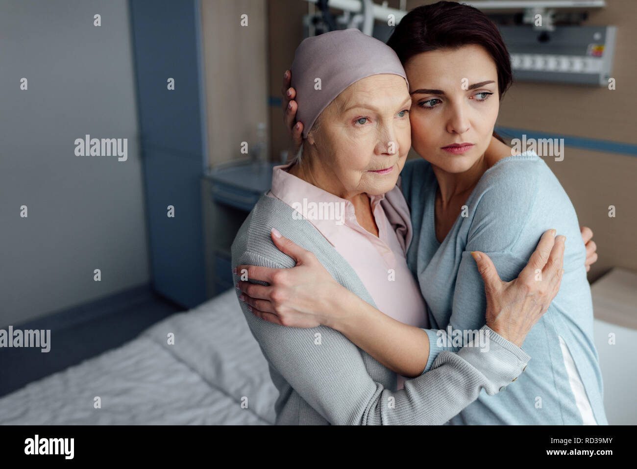 sad daughter embracing sick senior mother with cancer in hospital Stock ...