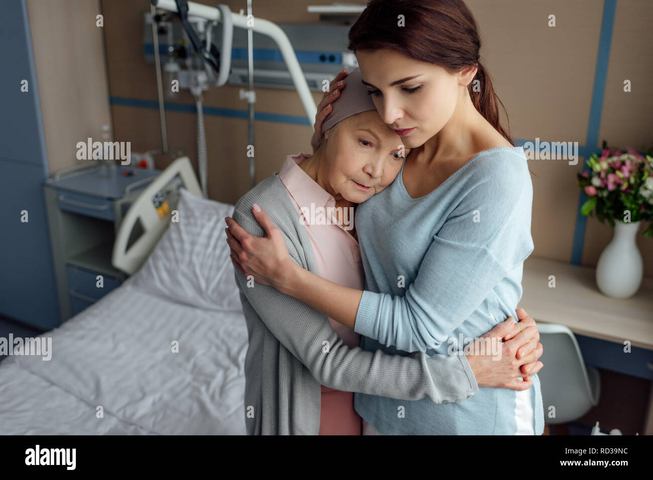 sad daughter hugging sick senior mother with cancer in hospital Stock ...