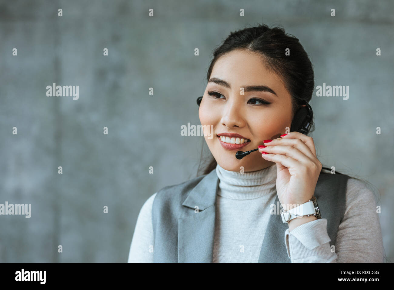 beautiful smiling call center operator in headset looking away on grey Stock Photo - Alamy