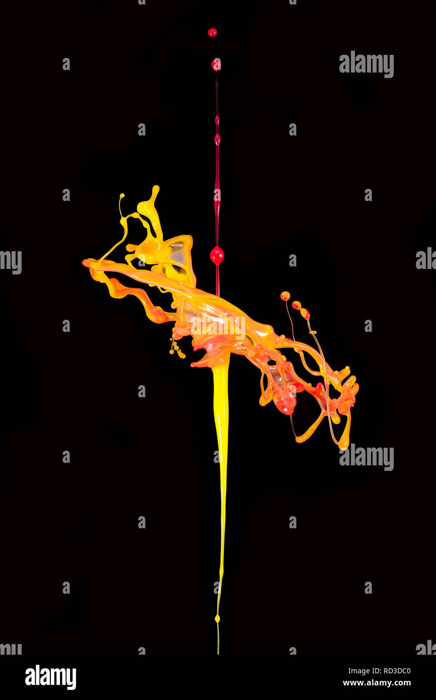 Yellow water splash against a black background Stock Photo - Alamy