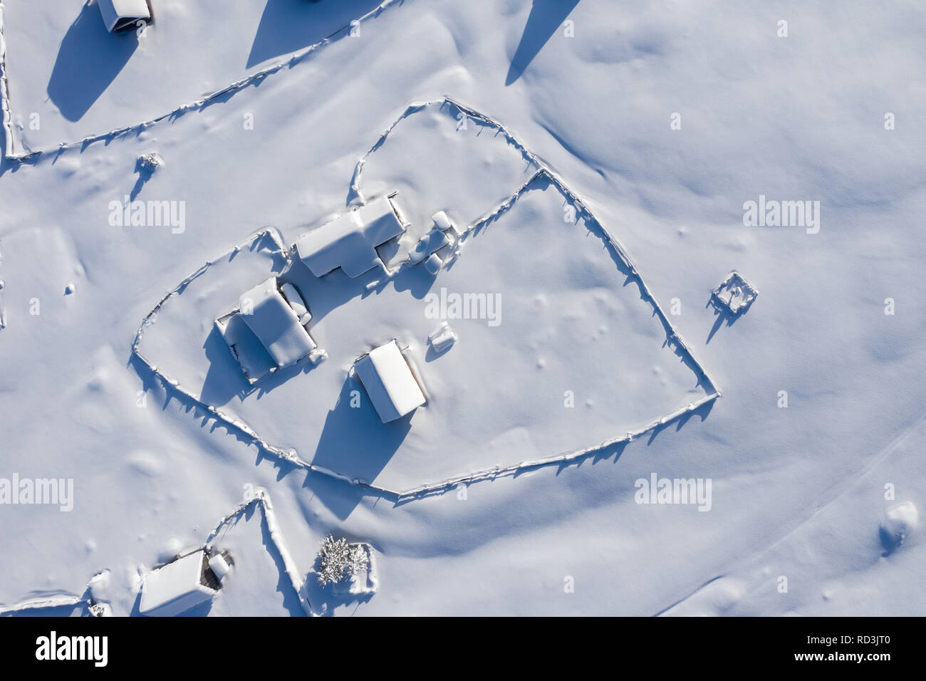 Snow covered remote village, homestead in the mountains. Aerial drone ...