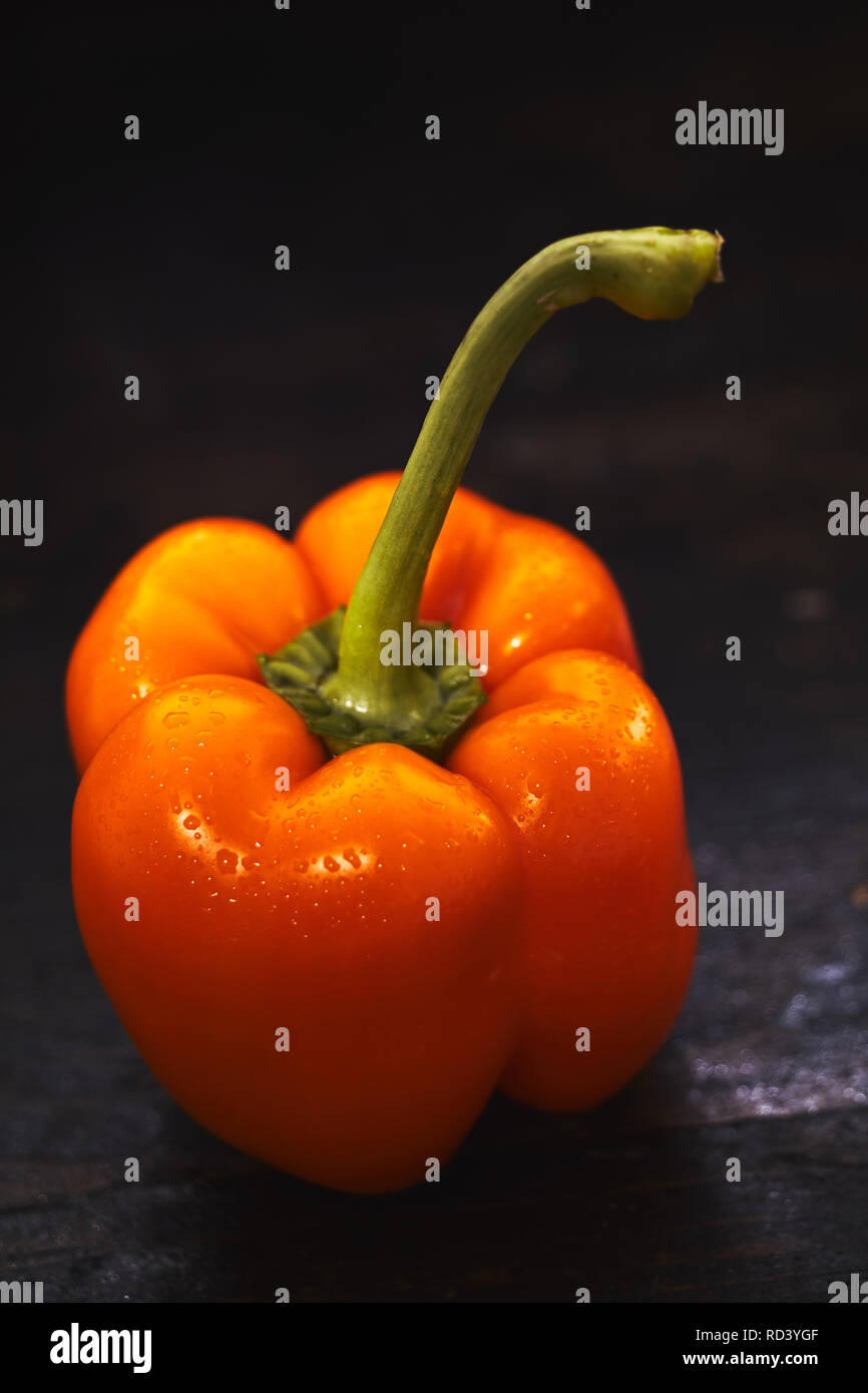 Healthy fresh raw orange sweet pepper with stalk rich and water drops ...