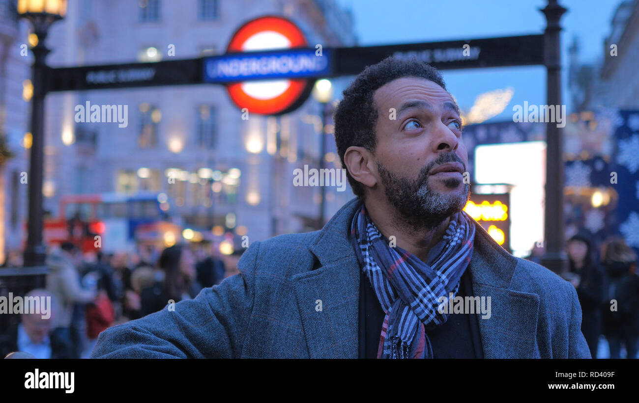 Man on a sightseeing trip in the streets of London at Piccadilly Circus ...