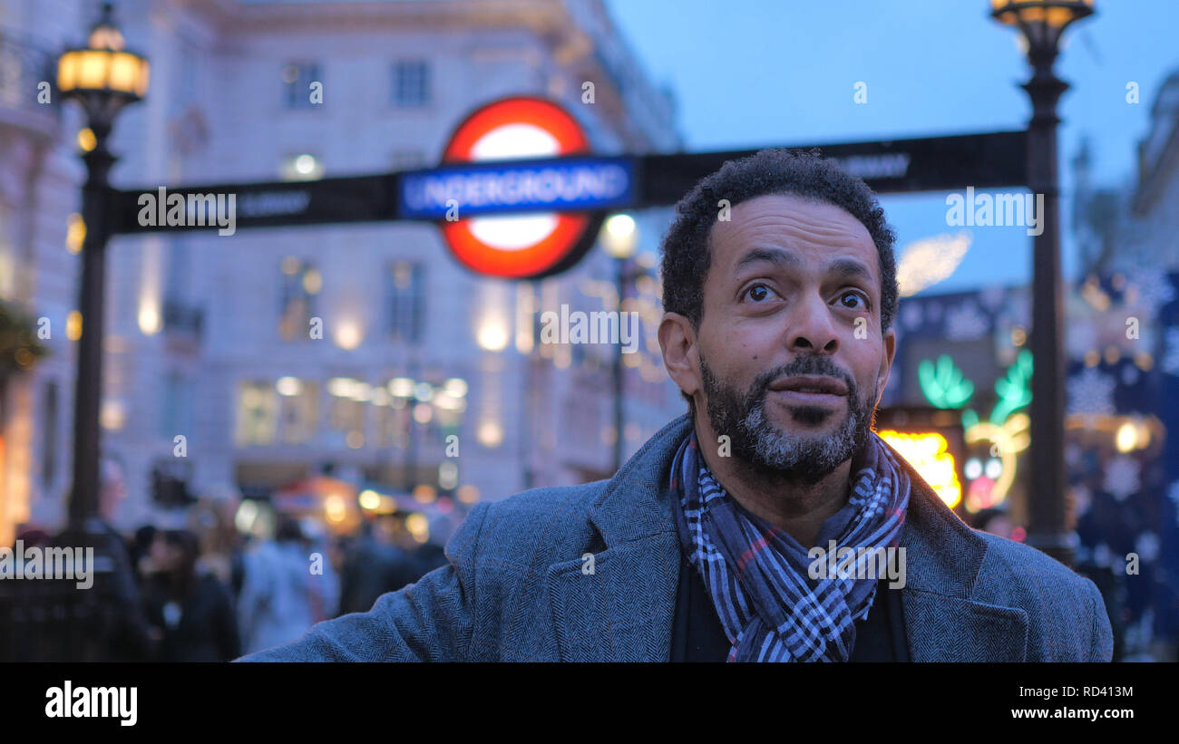 Man on a sightseeing trip in the streets of London at Piccadilly Circus ...