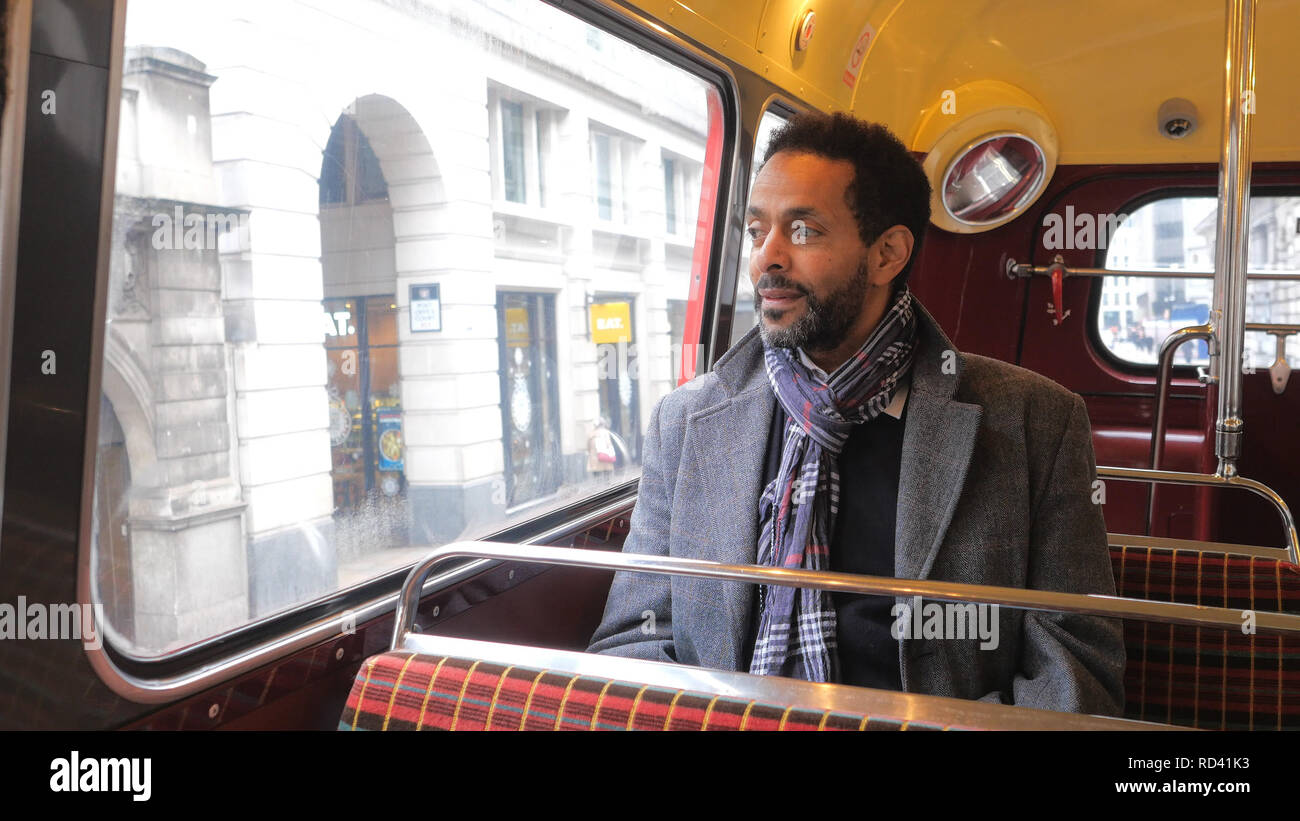 Man sits in an old London bus while travelling through the city Stock ...