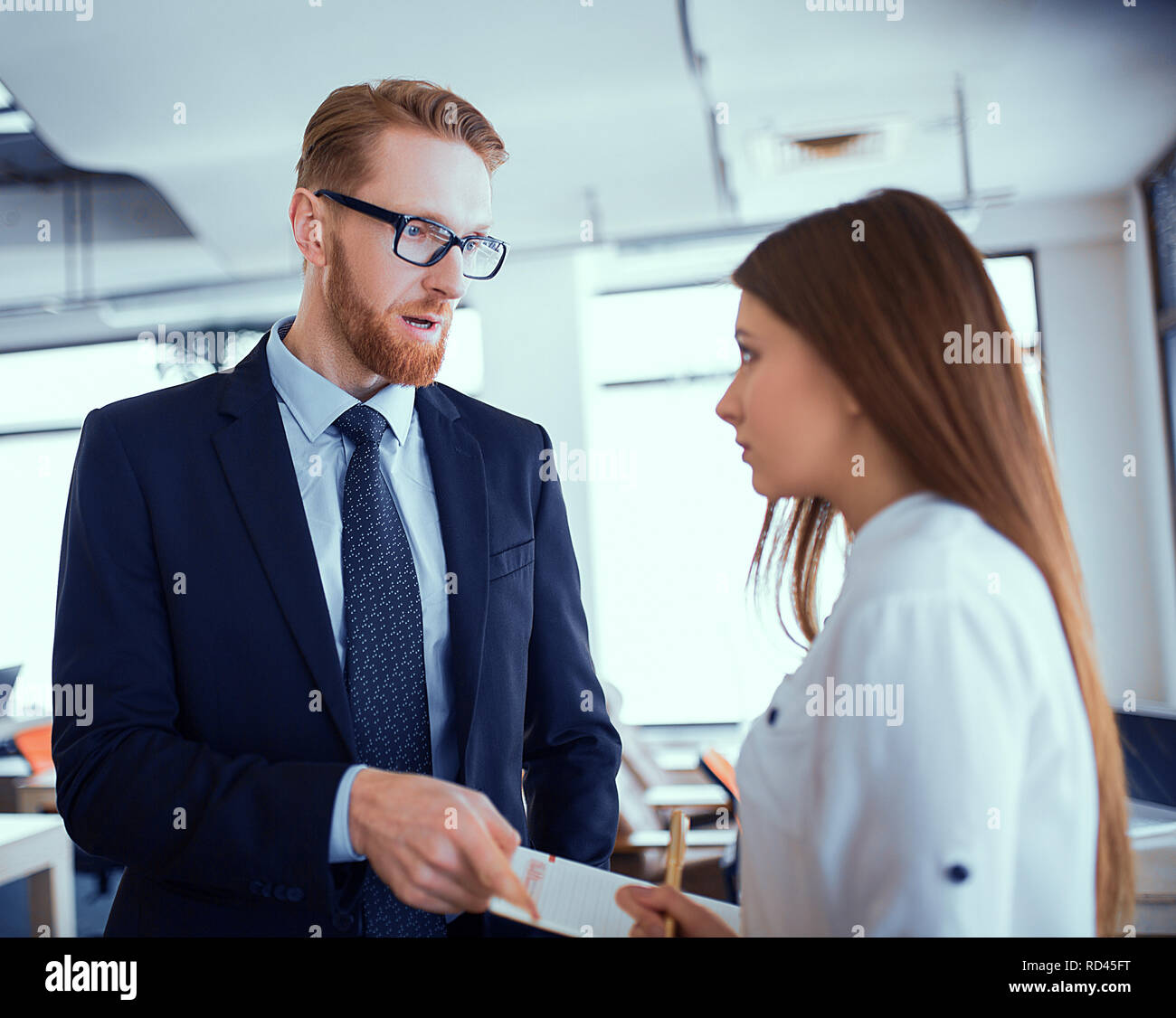 Manager and secretary with notepad in the office Stock Photo - Alamy