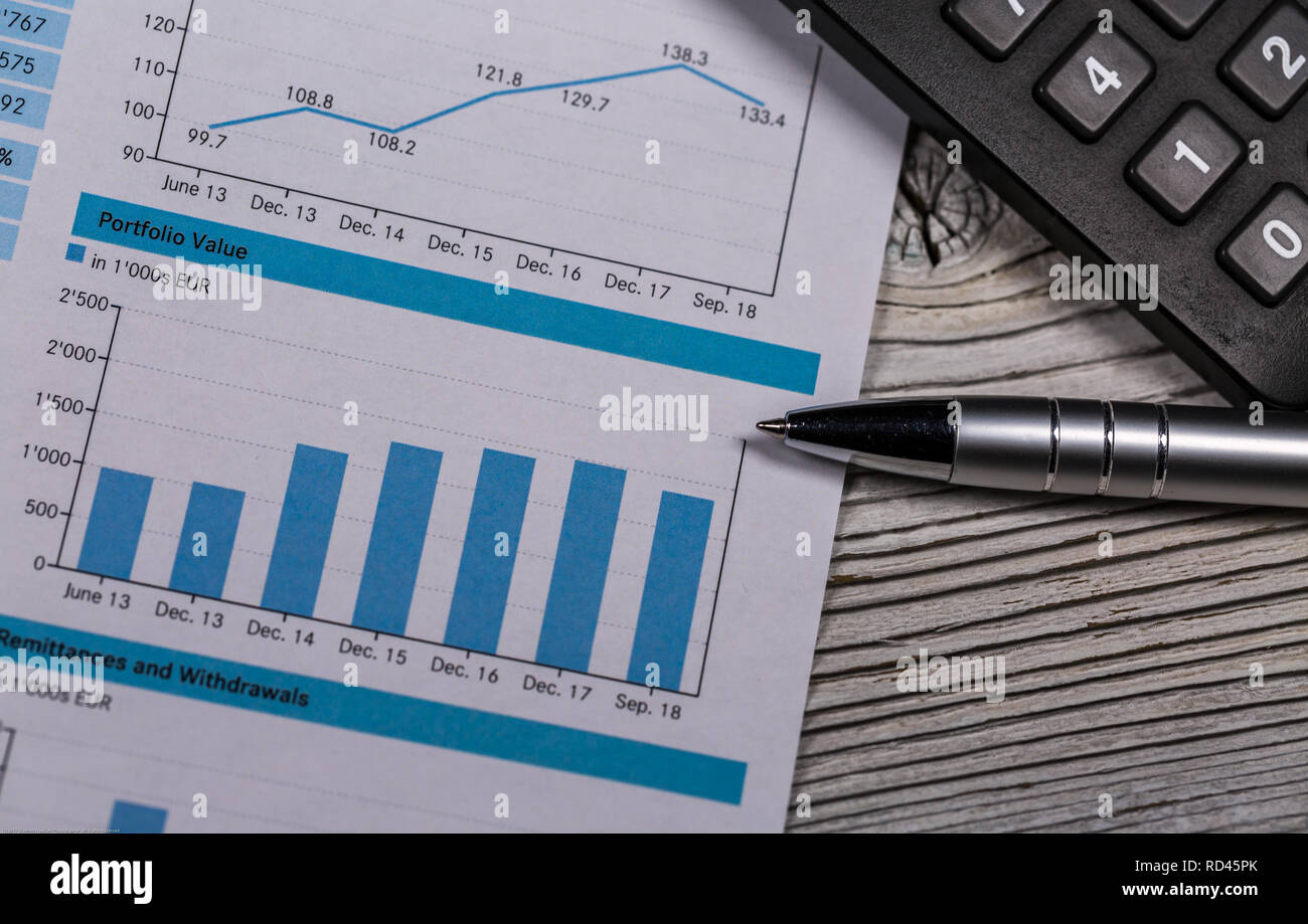 Financial graphs and charts ,calculator and pen on lying on table Stock ...