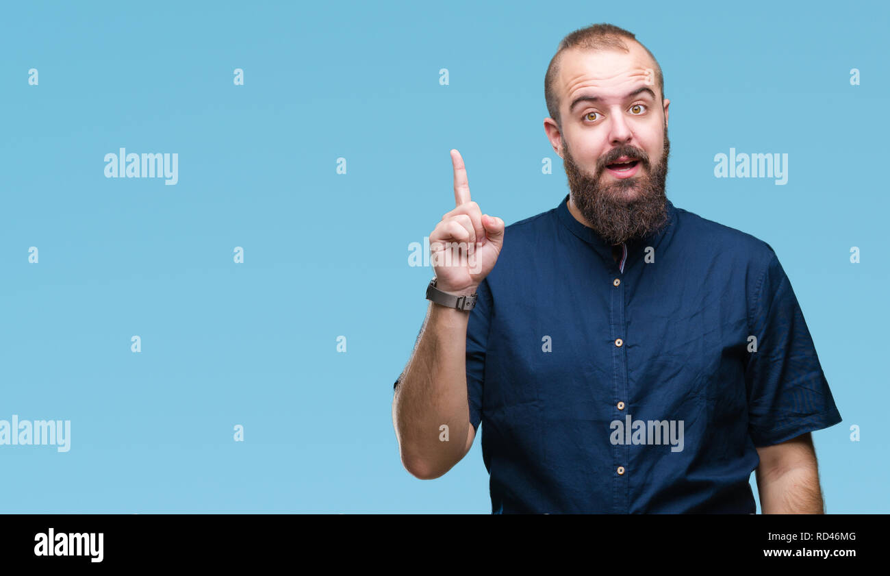 Young caucasian hipster man over isolated background pointing finger up ...