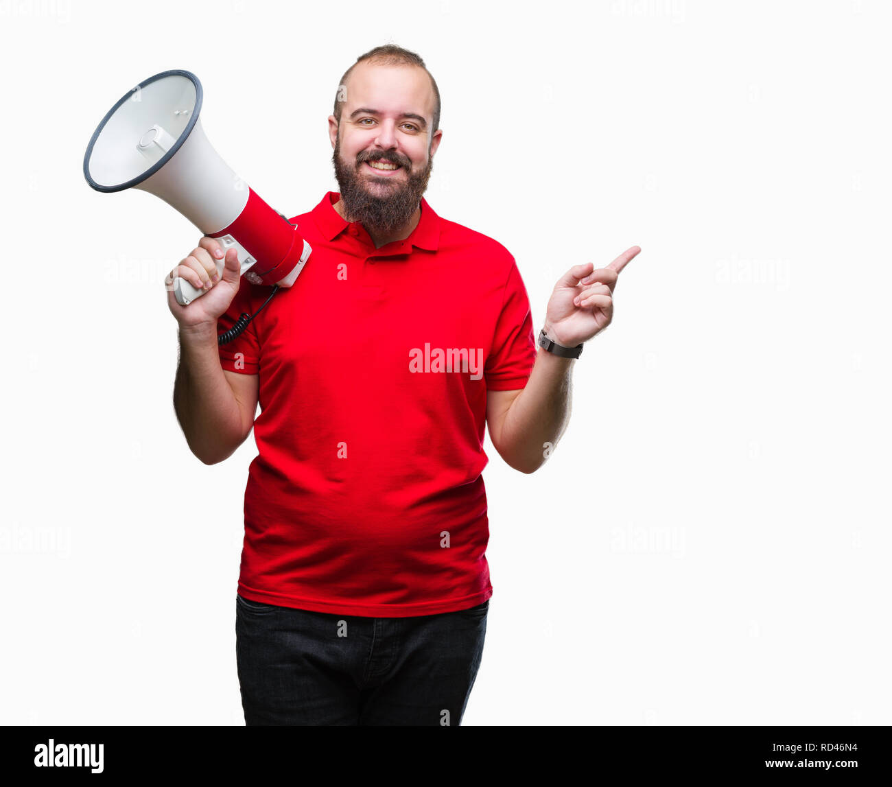 Young caucasian man shouting through megaphone over isolated background ...