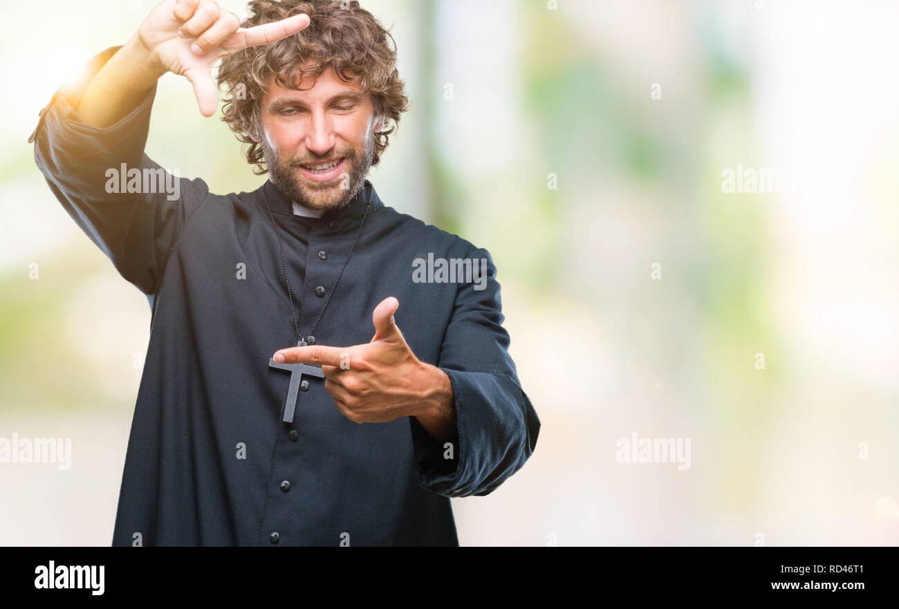 Handsome hispanic catholic priest man over isolated background smiling ...