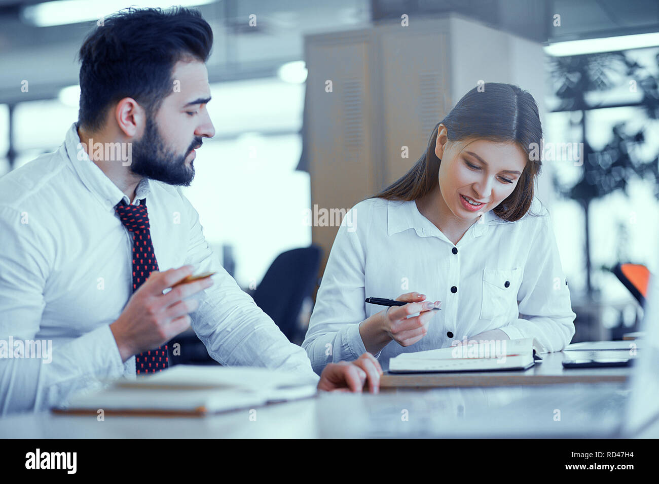 A couple of colleagues at the desk Stock Photo - Alamy